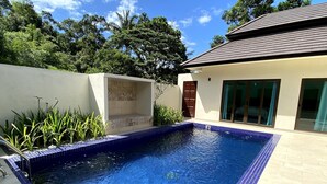 Piscina com azulejos azuis, um banco revestido em azulejo, e uma casa com telhado e porta em azulejo.
