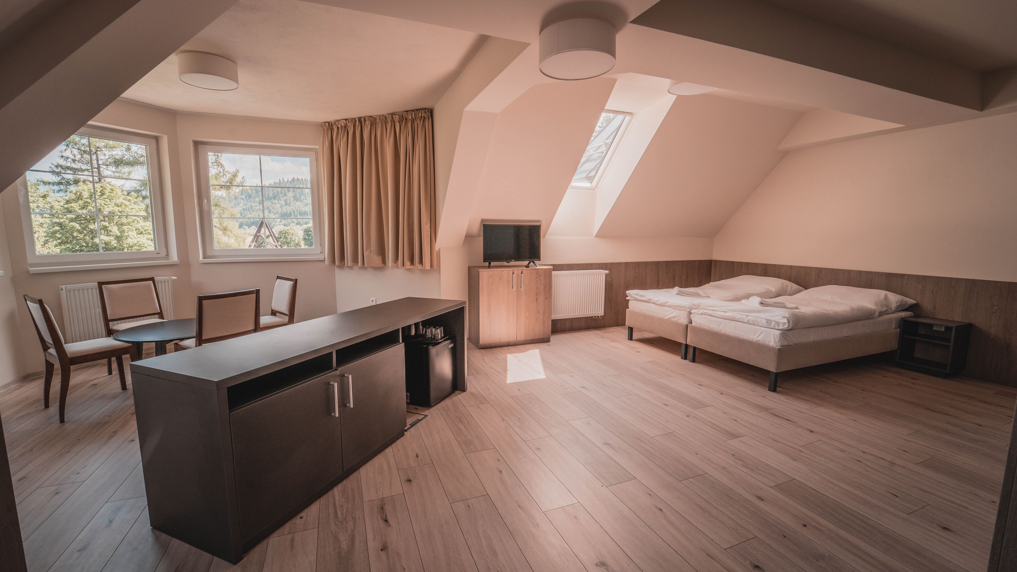 Quarto moderno estilo loft, com uma cama grande, escrivaninha e televisão.