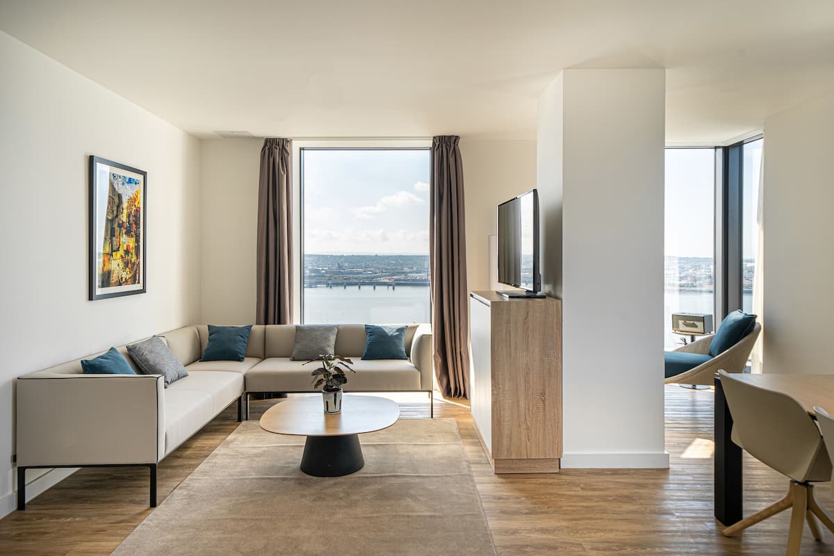 Uma sala de estar moderna com sofá, mesa de centro e televisão.