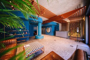 Um lobby moderno com esquema de cores azul, área de estar circular e uma mesa de centro.
