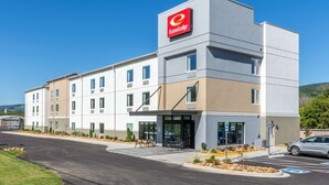 Um edifício moderno do EconoLodge com telhado plano, várias janelas e um estacionamento com vagas demarcadas.