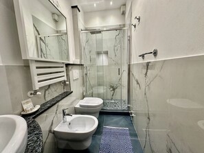 Quarto Quádruplo Premium | Casa de banho | Um polibã, um chuveiro fixo, um secador de cabelo, um bidé