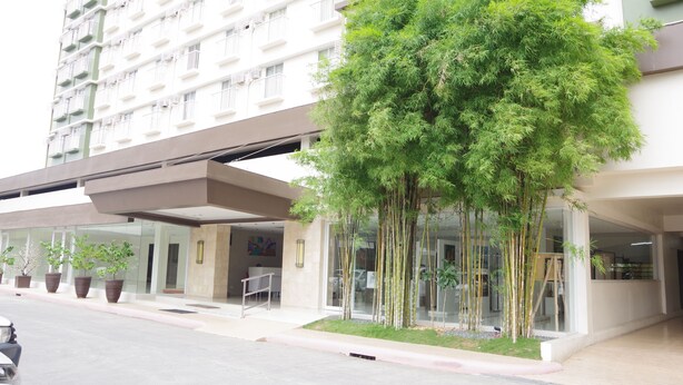 Edifício moderno com entrada de vidro, plantas em vasos e vista clara do interior.