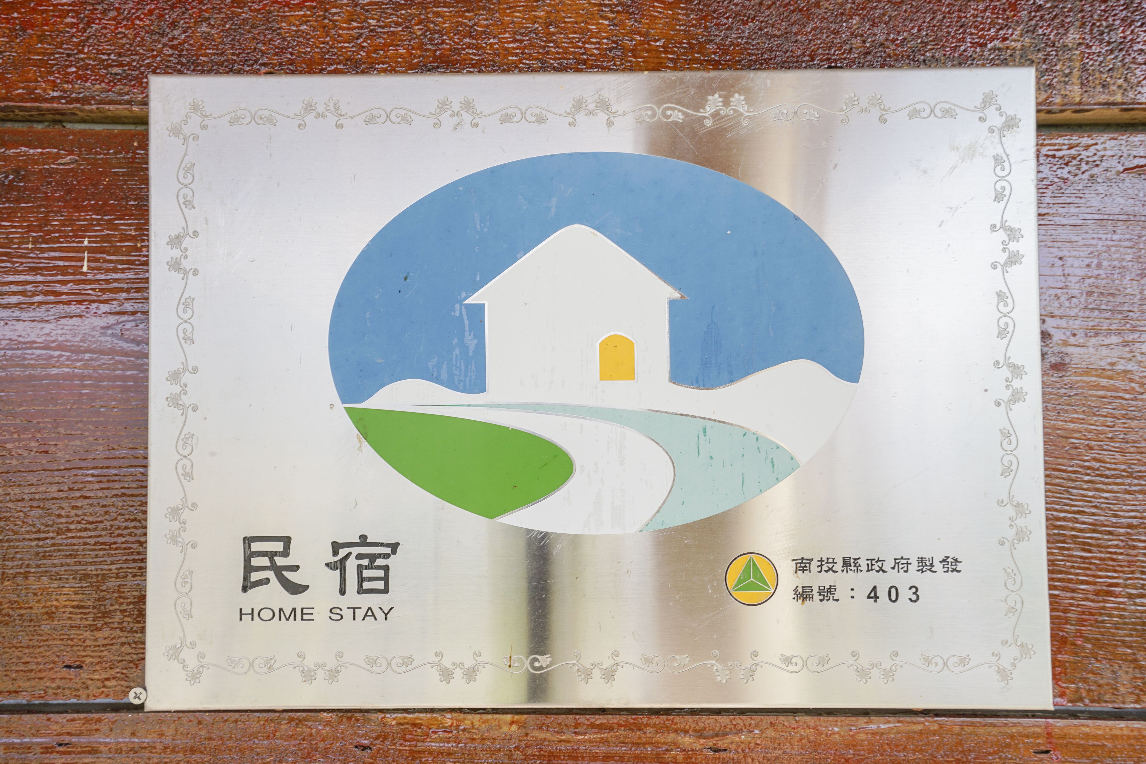 Placa com uma casa e uma estrada sinuosa, identificada como 'Home Stay' e '403'.