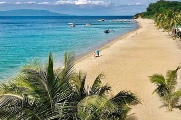 Na praia, areia branca, prática de mergulho livre no local