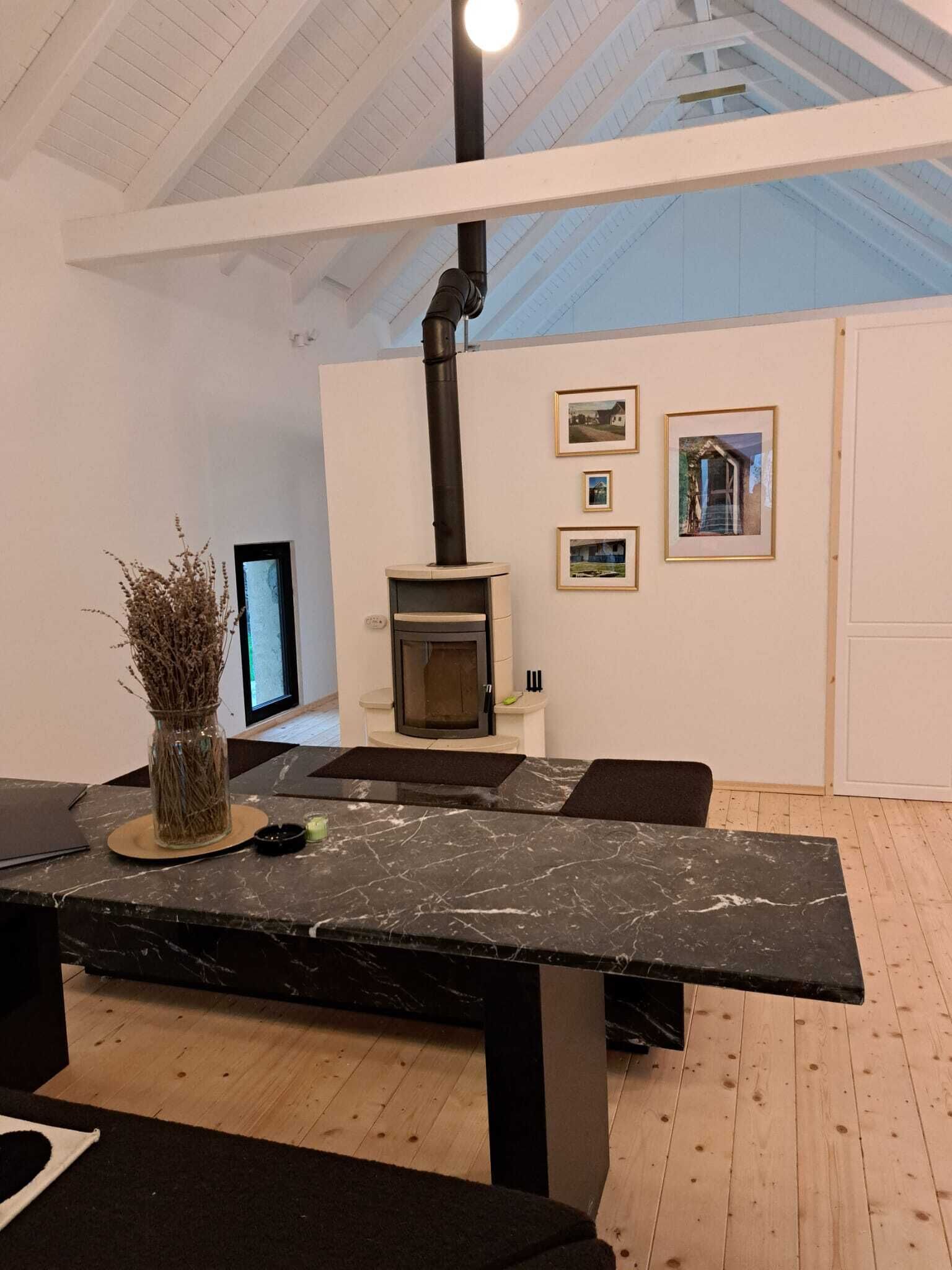 Um interior moderno com lareira, quadros nas paredes e uma mesa de mármore.