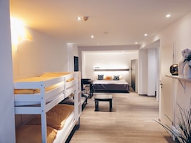 Quarto moderno com beliche, escrivaninha e guarda-roupa.