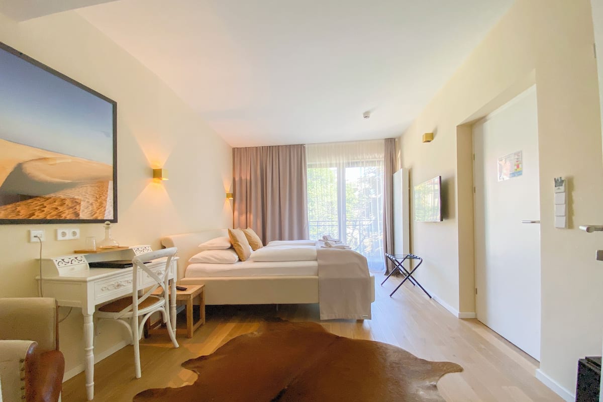 Quarto de hotel moderno com uma cama grande, uma escrivaninha e um tapete de couro.