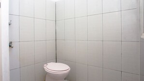 Um banheiro pequeno com vaso sanitário e paredes revestidas com azulejos.