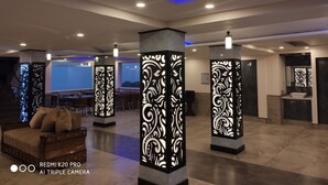 Um lobby moderno com pilares decorativos, um sofá e uma área de recepção.