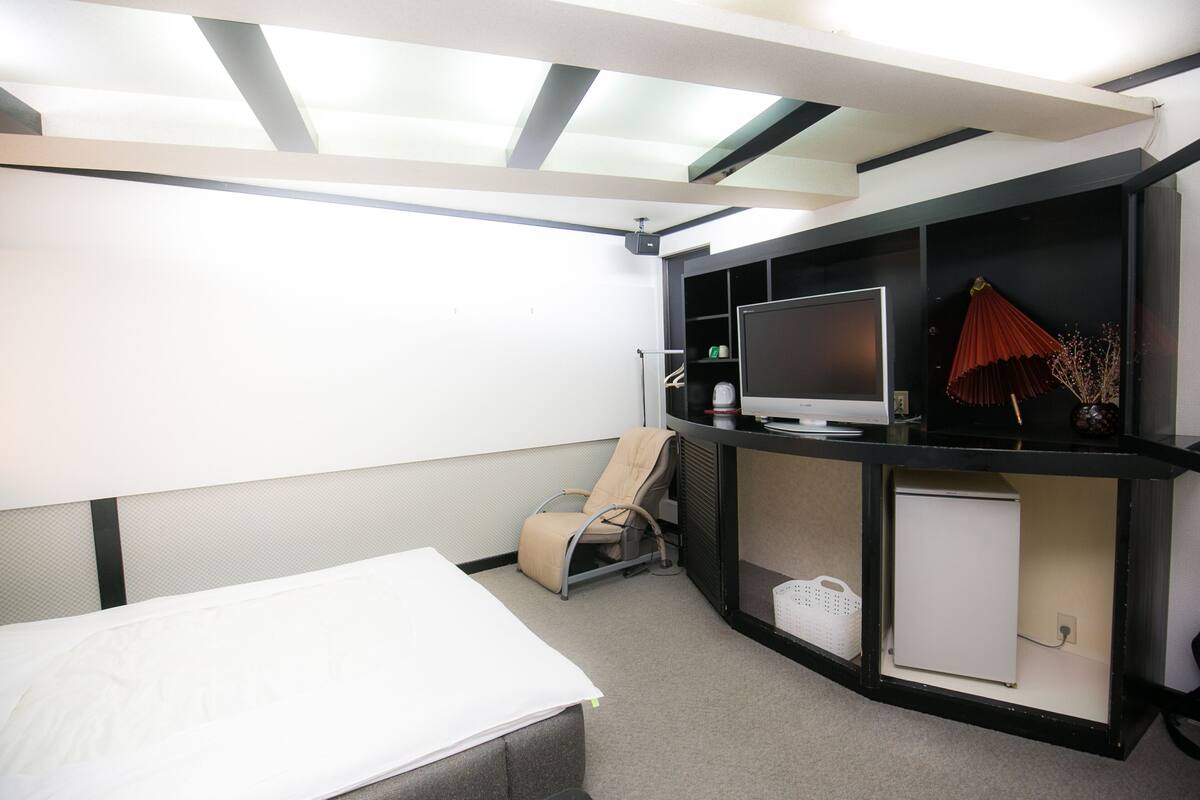 Um espaço de escritório moderno com uma mesa, cadeira e um pequeno armário branco.