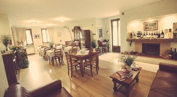 Uma sala de estar ampla com área de jantar, móveis de madeira e lareira.