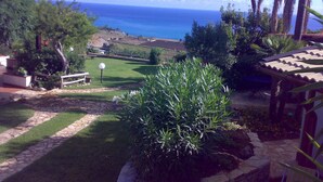 Um jardim com um caminho que leva a uma vista do oceano.
