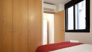 Um quarto com uma cama, um guarda-roupa e uma janela.
