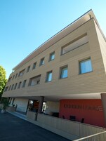 Um edifício moderno com telhado plano e uma placa vermelha que diz "OCHSEN LODGE".