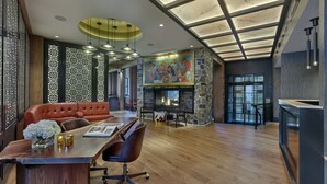 Um quarto espaçoso com mesa de jantar de madeira, sofá de couro e lareira.