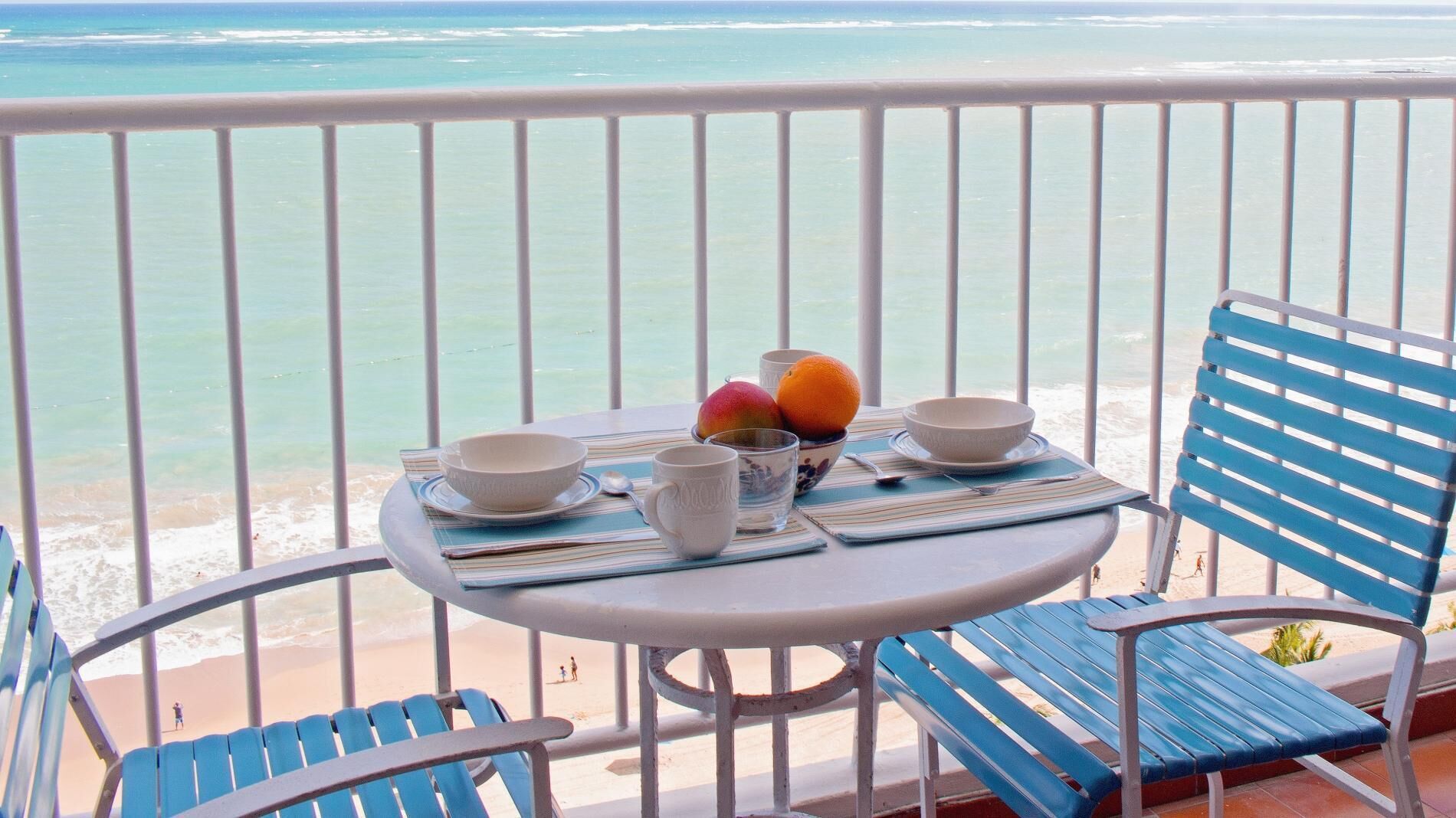 Varanda com uma mesa posta para dois, com vista para a praia.