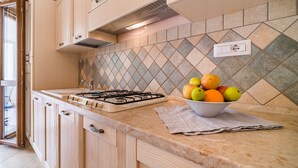 Uma cozinha com armários de madeira, fogão a gás e painel de azulejos.