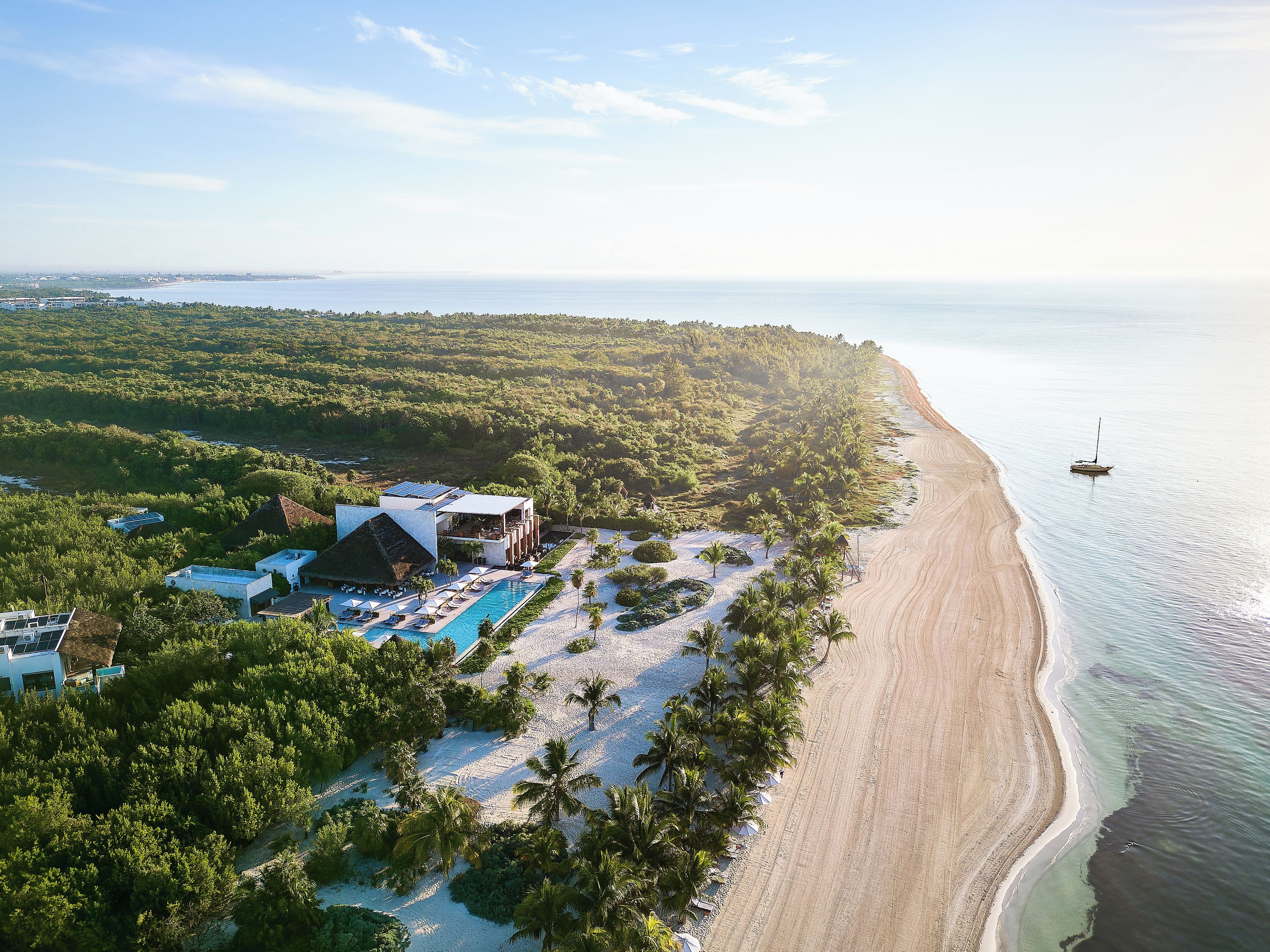 Um resort com piscina, praia e vista para o oceano.