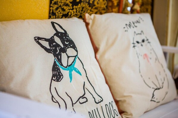 Dois travesseiros com ilustrações de cães na cama.