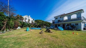 Uma área residencial com um grande edifício branco, com varanda e janelas em arco.