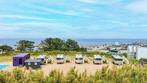 Uma fileira de casas móveis à beira-mar, com vista para o mar e uma piscina pequena.