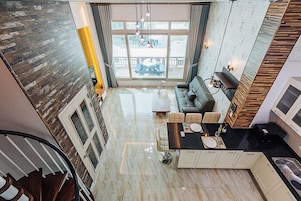 Cozinha moderna com ilha central, área de refeições com sofá e uma janela ampla com vista para o exterior.