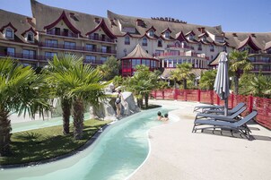 Um resort com piscina, palmeiras e espreguiçadeiras.