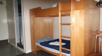 Uma cama beliche com estrutura de madeira e colchão.