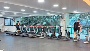 Academia com esteiras, bicicletas ergométricas e aparelhos de musculação.