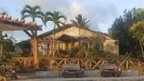 Uma área de piscina com espreguiçadeiras e um edifício com um terraço.