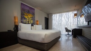 Quarto de hotel moderno com uma cama grande, uma escrivaninha e uma cadeira.