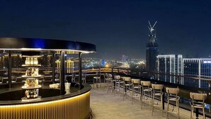 Um bar no terraço com vista para a cidade, com balcão e área de estar.