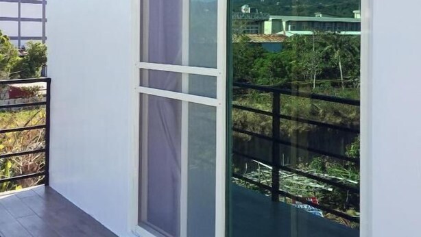 Um edifício moderno com uma janela ampla e uma varanda.