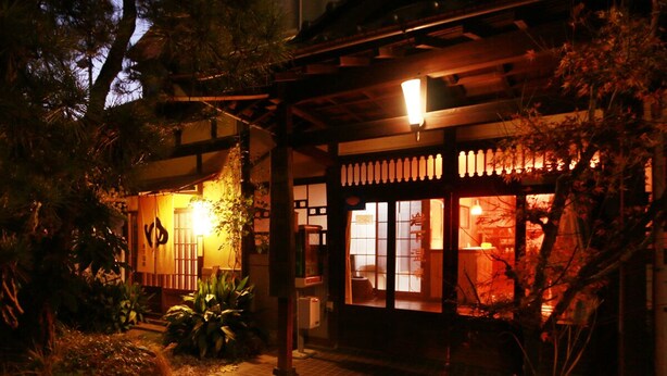 Um edifício japonês tradicional com fachada de madeira e entrada coberta.
