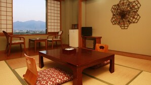 Um quarto japonês tradicional com tatames, uma mesa baixa e cadeiras.