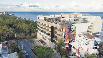 Um hotel moderno com várias varandas com vista para a praia e o oceano.