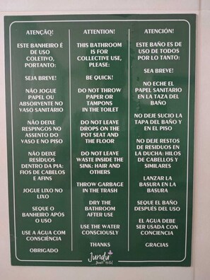 Uma placa de banheiro bilíngue, em português e inglês, com instruções de uso.