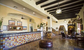 Um hall com piso de azulejos, uma mesa de recepção e uma placa para The Gateway Hotels.