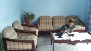 Um quarto com um sofá, uma mesa de centro e uma planta em vaso.