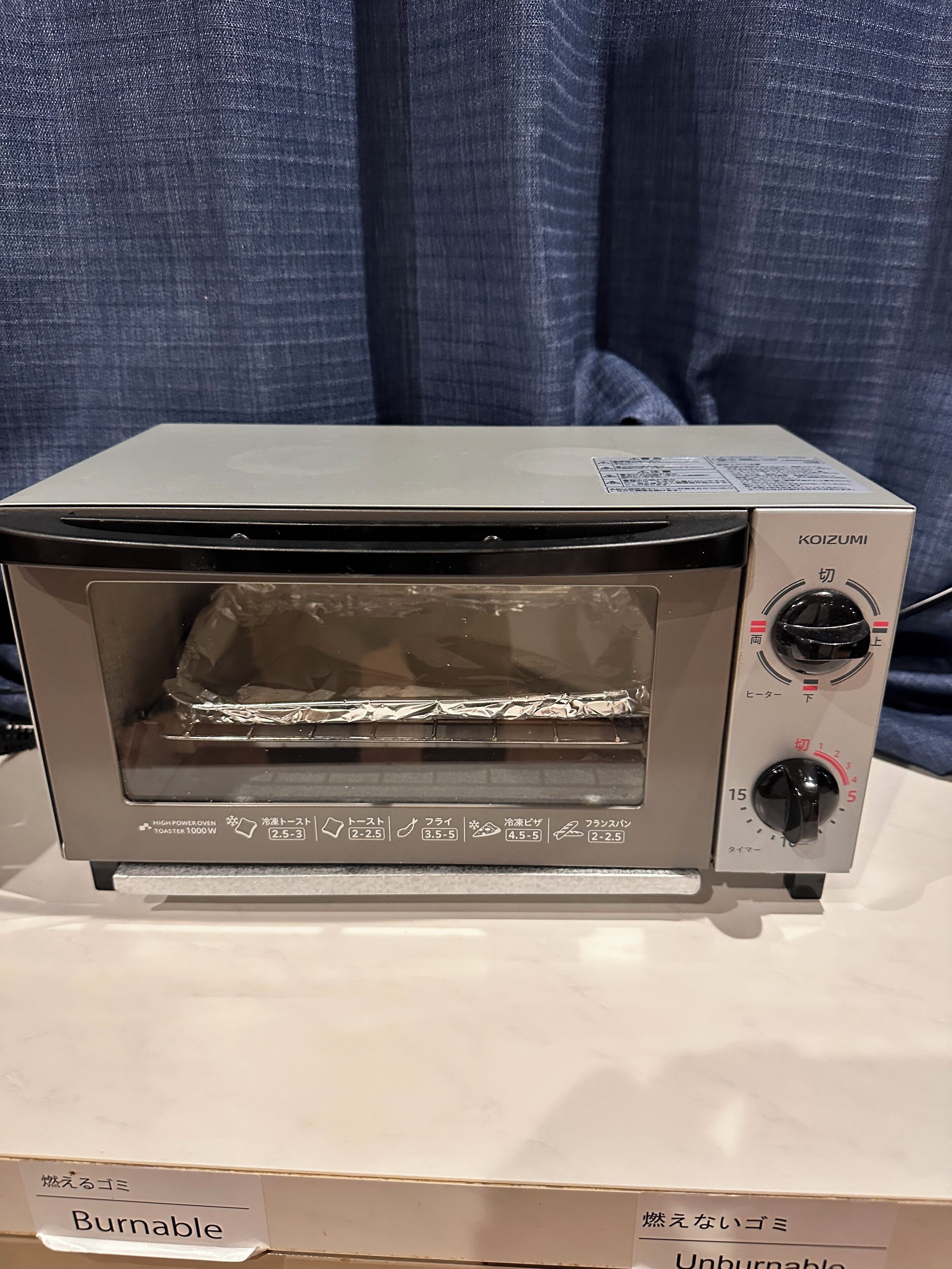 Um forno elétrico pequeno com visor digital e botões de controle.