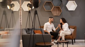 Uma sala de estar moderna com sofá, mesa de centro e decorações hexagonais na parede.