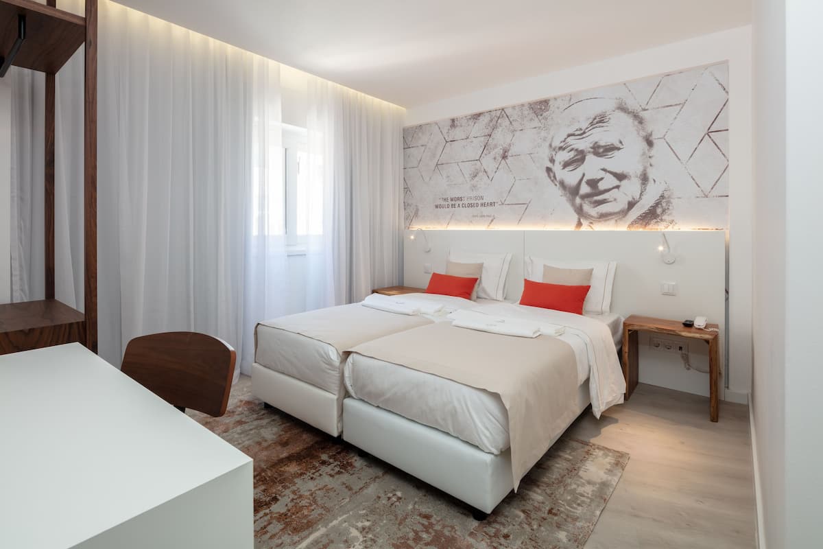 Quarto moderno com uma cama grande, uma escrivaninha e uma cadeira.