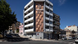 Um hotel com vários andares e uma placa grande com a inscrição "The Icons Hotel".