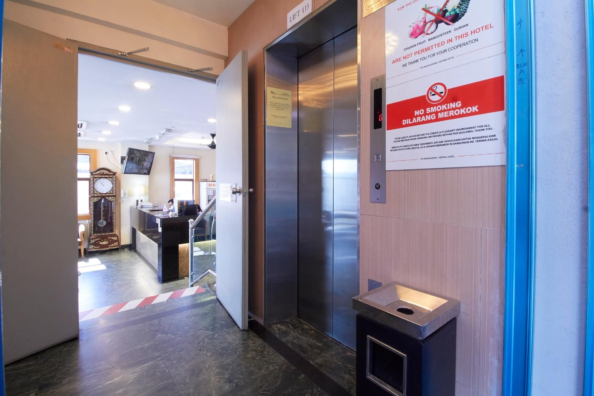 Um elevador com uma placa que proíbe fumar e um botão de chamada.