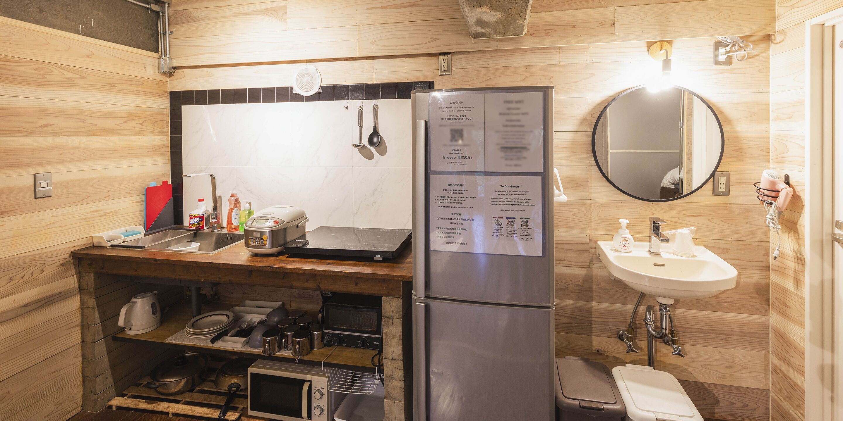 Uma cozinha compacta com geladeira, micro-ondas e pia.