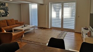 Uma sala de estar com sofá, mesa de centro e televisão em um móvel.