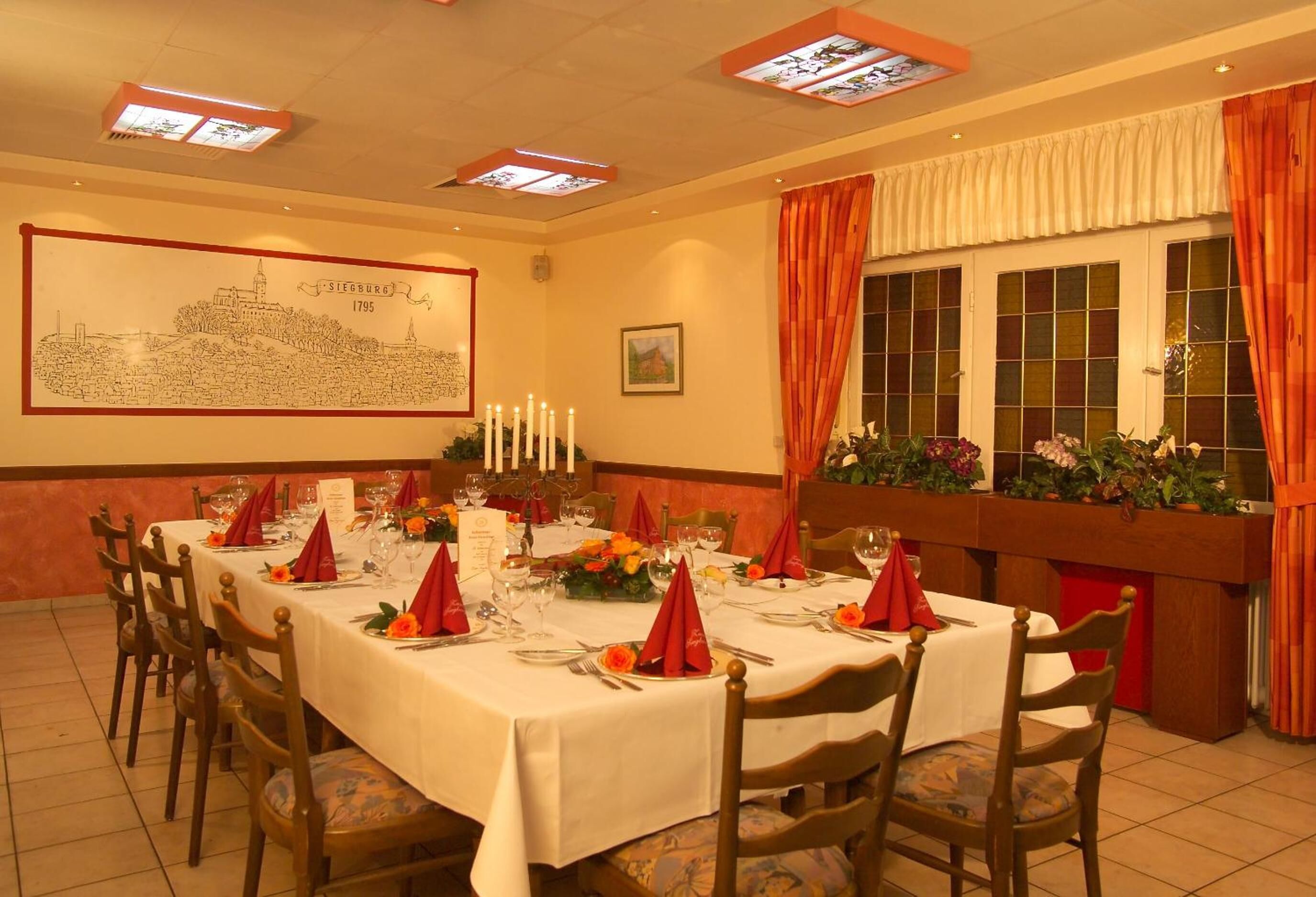 Uma sala de jantar com mesas preparadas para uma refeição, um grande mapa histórico emoldurado na parede e uma janela com cortinas.
