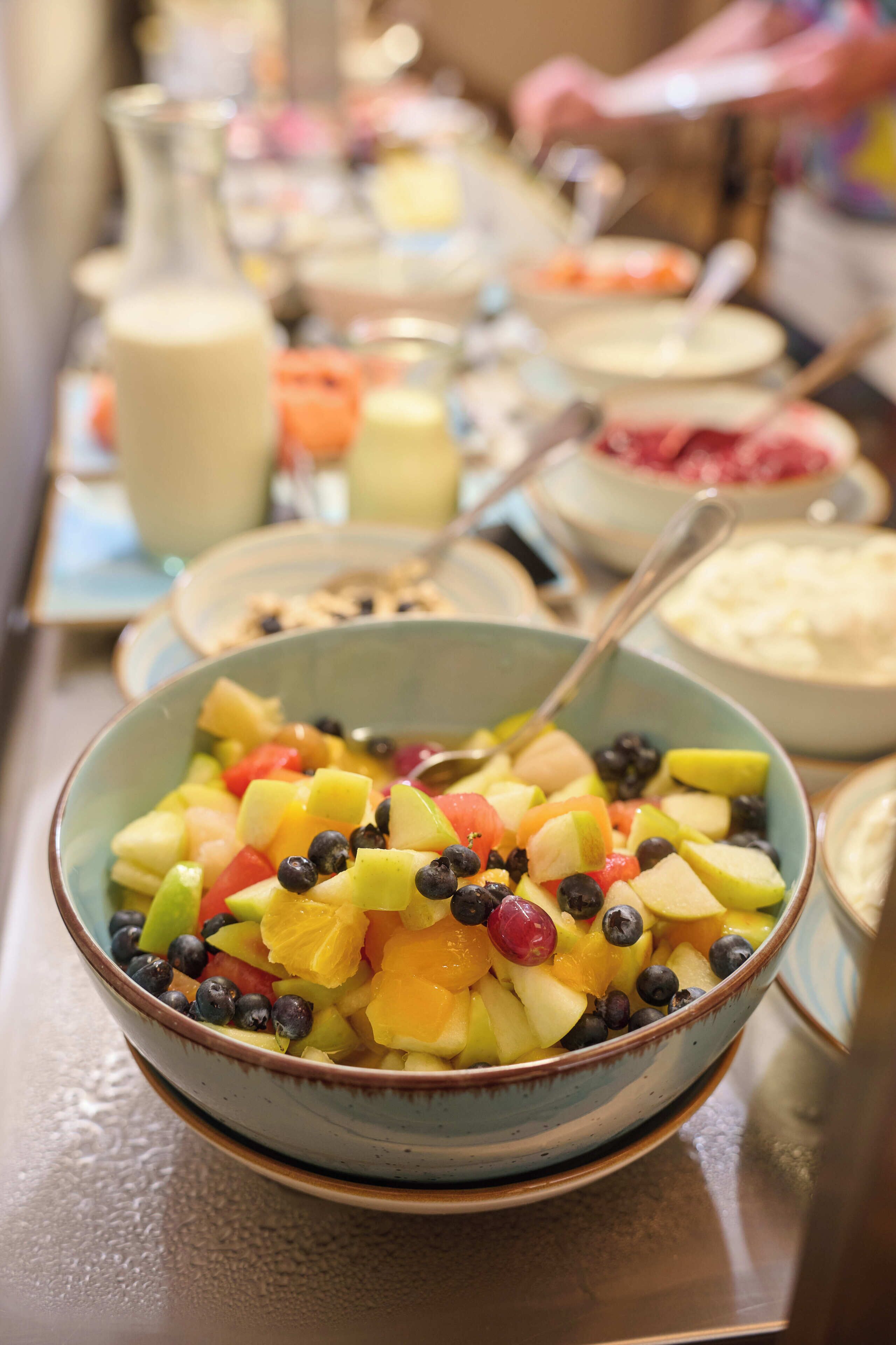 Buffet com uma saladeira em primeiro plano.