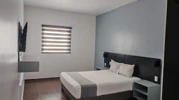 Quarto moderno com cama, mesas de cabeceira, janela com persianas e prateleira na parede.